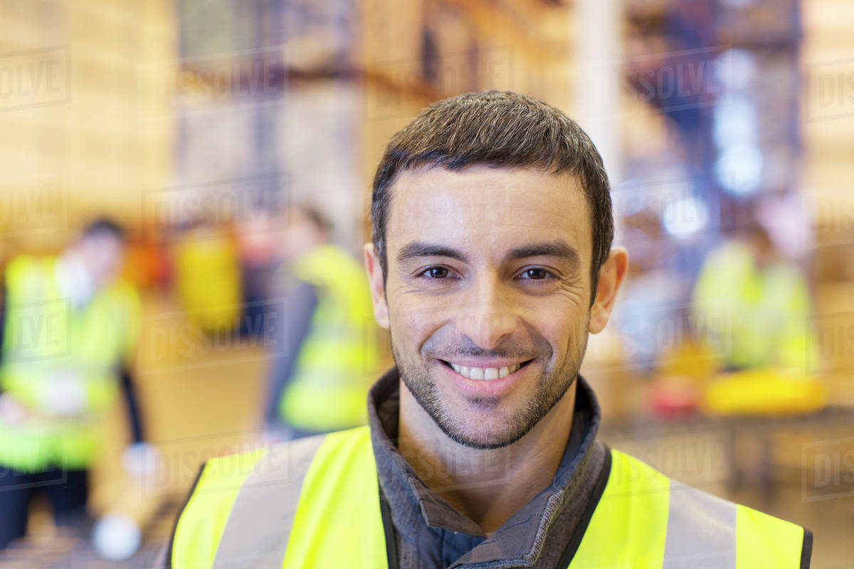 Worker smiling in warehouse - Royalty-free Stock Photo | Dissolve