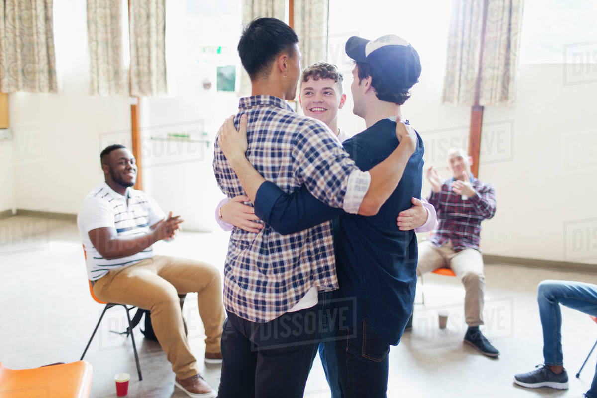 Men hugging in group therapy - Royalty-free Stock Photo | Dissolve