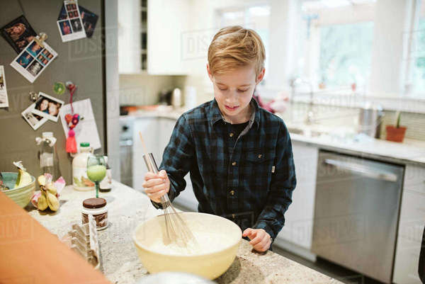 Tween boy baking in kitchen - Stock Photo - Dissolve