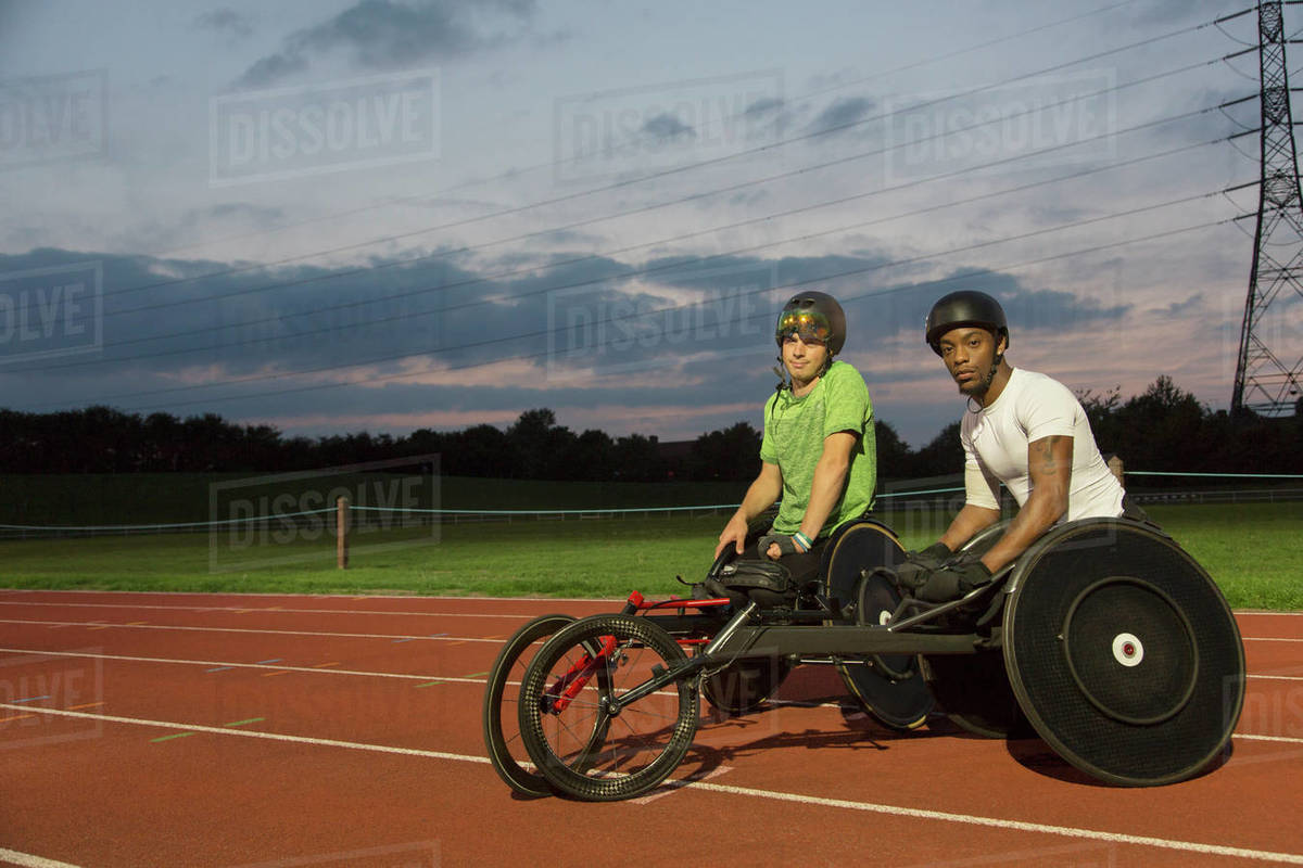 Portrait confident paraplegic athletes training for wheelchair race on ...