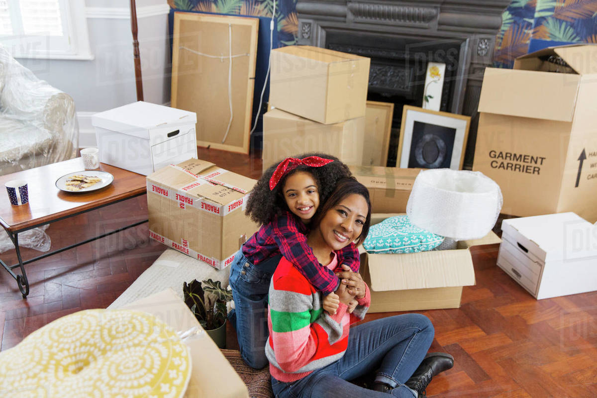 Portrait Happy Affectionate Mother And Daughter Hugging Among Boxes