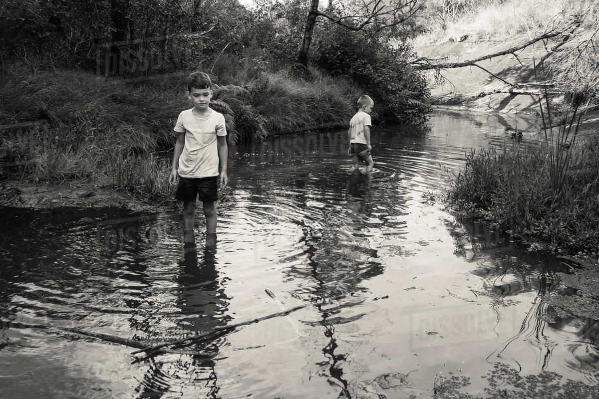 Boys wading in river - Royalty-free Stock Photo | Dissolve