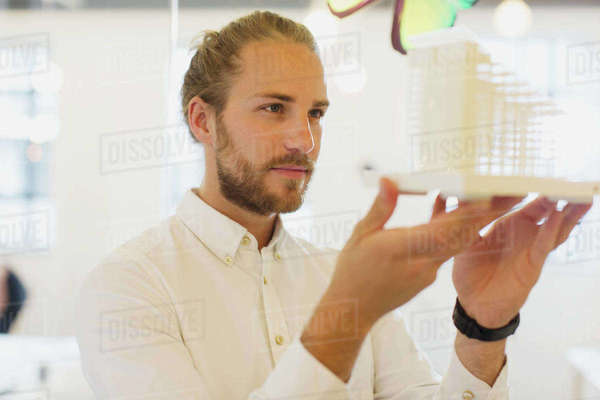 Focused, curious male architect examining model in office - Stock Photo ...
