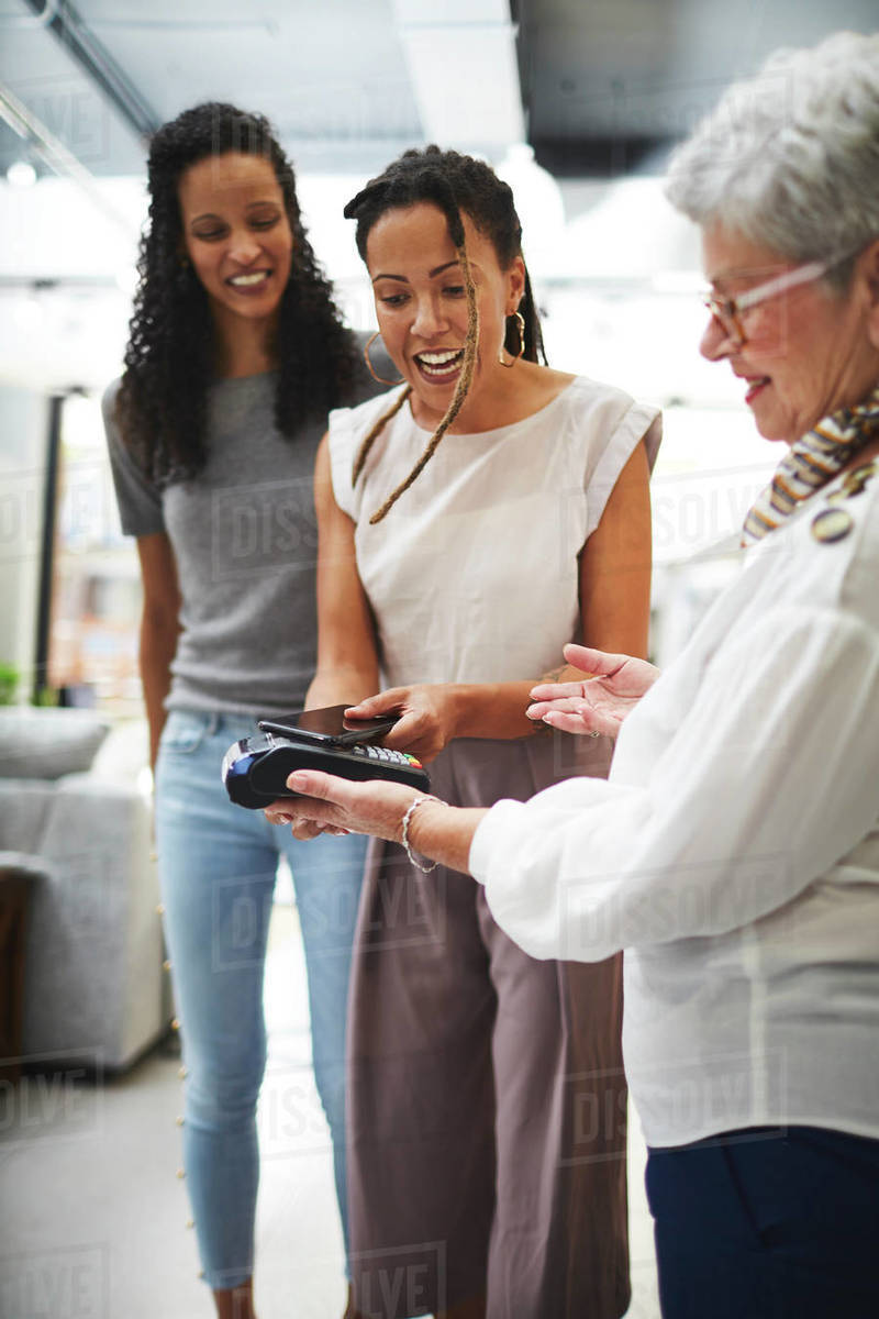Women paying worker with smart phone - Stock Photo - Dissolve