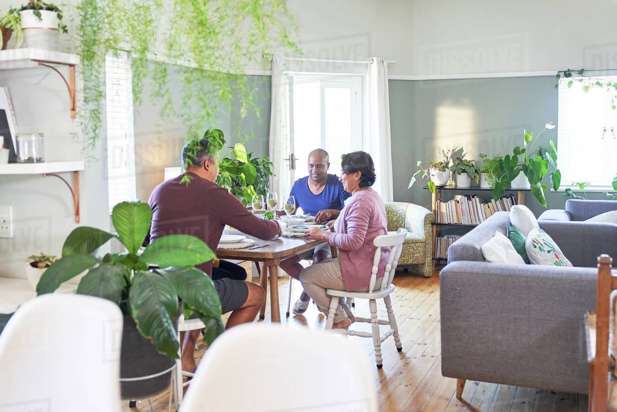 Mature friends eating lunch at dining table - Royalty-free Stock Photo ...