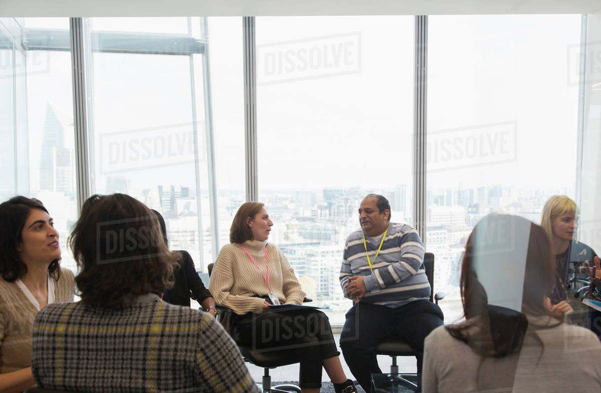Business people talking in circle in conference room meeting - Royalty ...