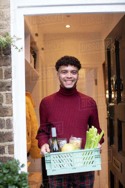 Happy young man receiving grocery delivery at front door - Royalty-free ...