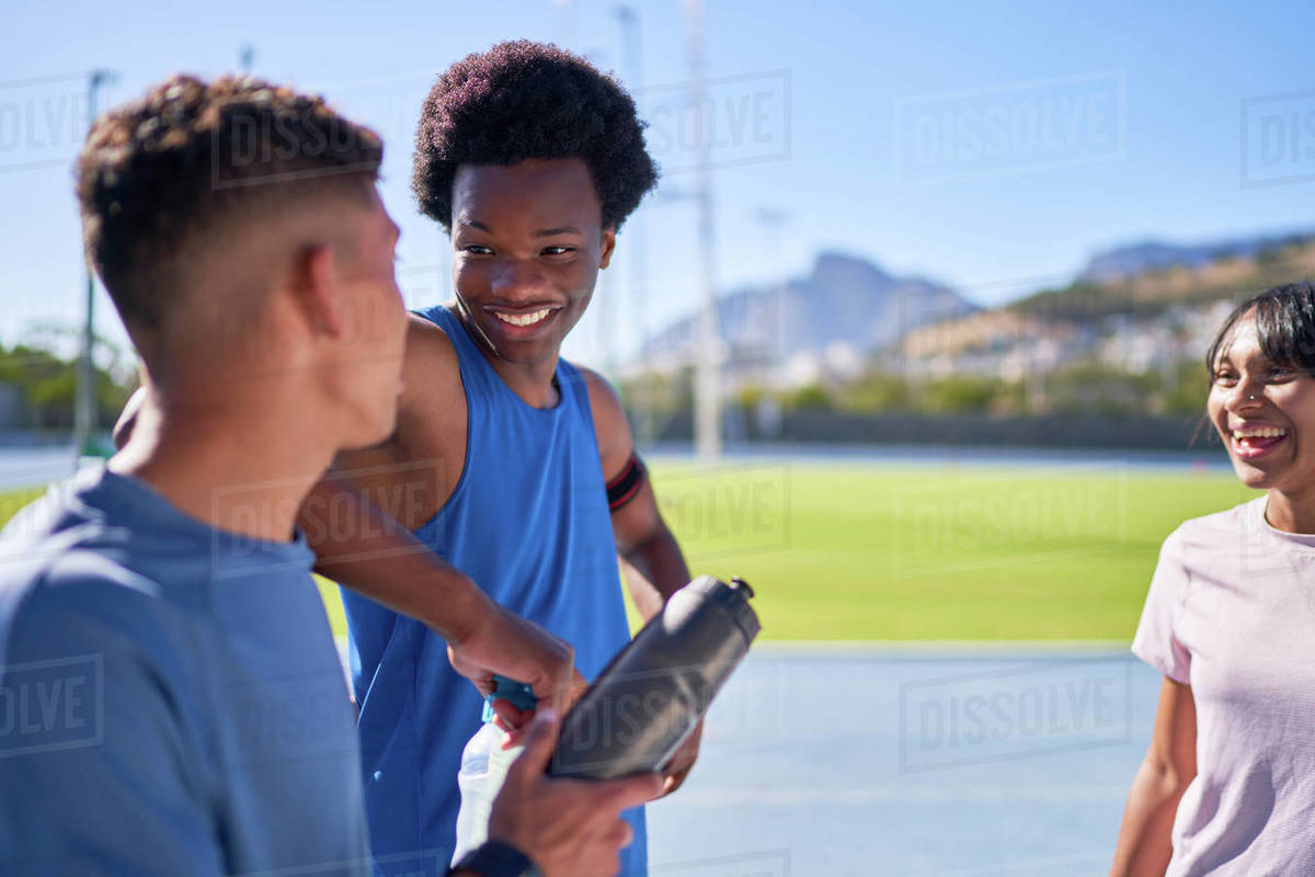 Happy young athletes talking on sunny sports track - Royalty-free Stock ...