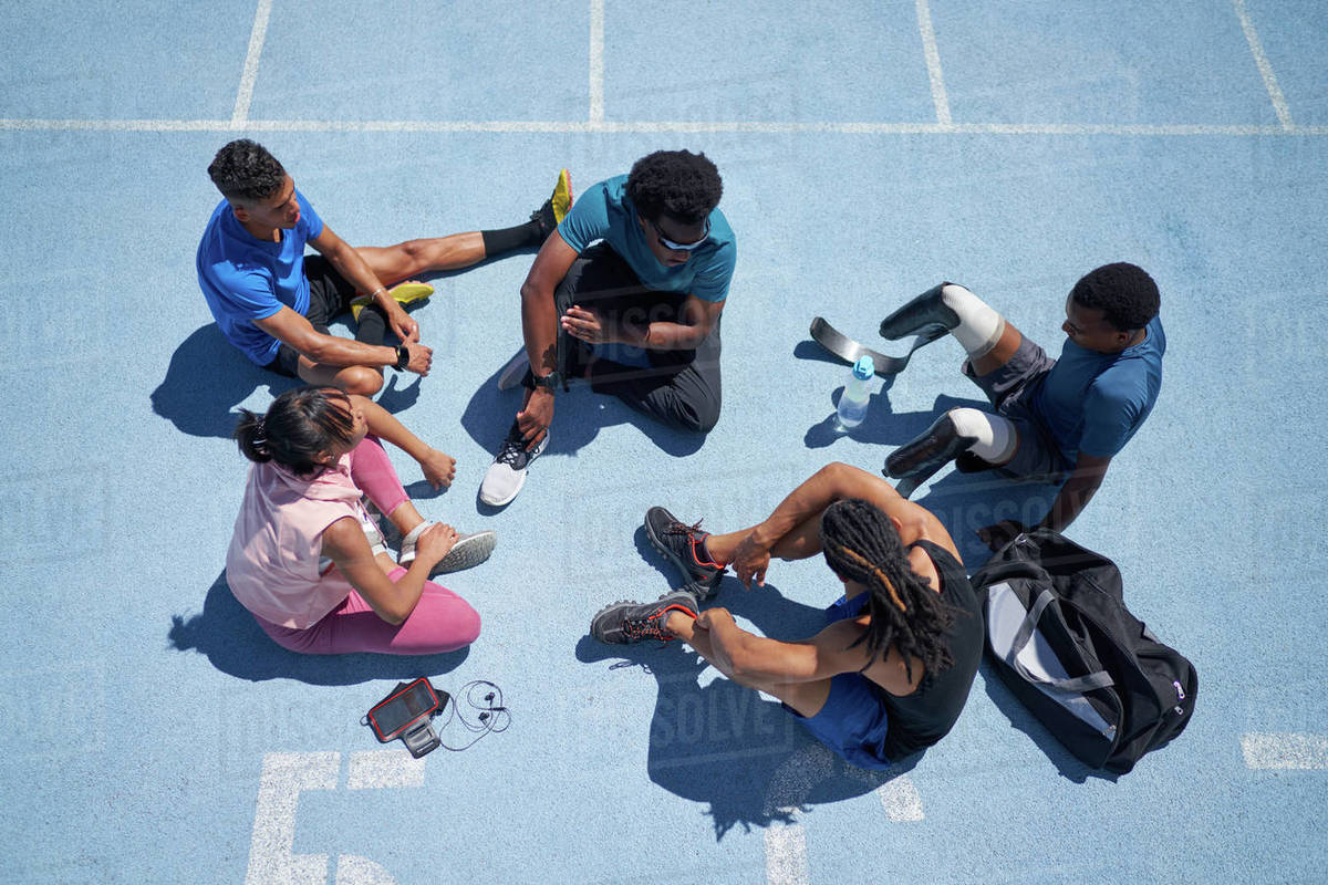 Young athletes talking on sunny blue sports track - Royalty-free Stock ...