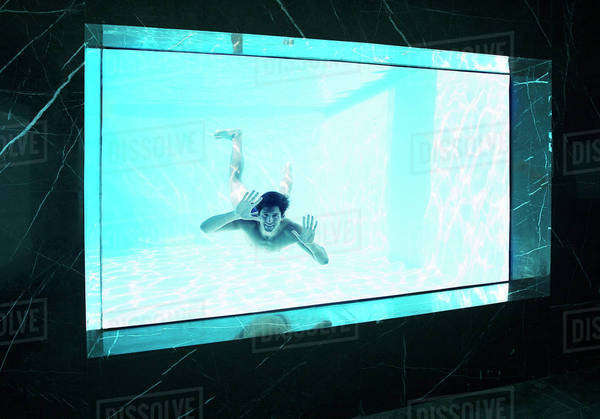 Man looking through window underwater in swimming pool - Stock Photo ...