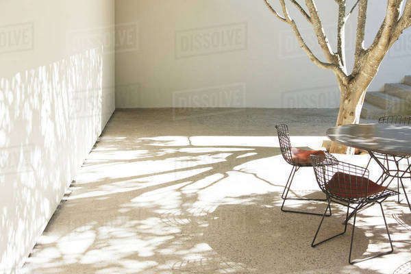 Table and chairs casting shadows in courtyard - Royalty-free Stock ...