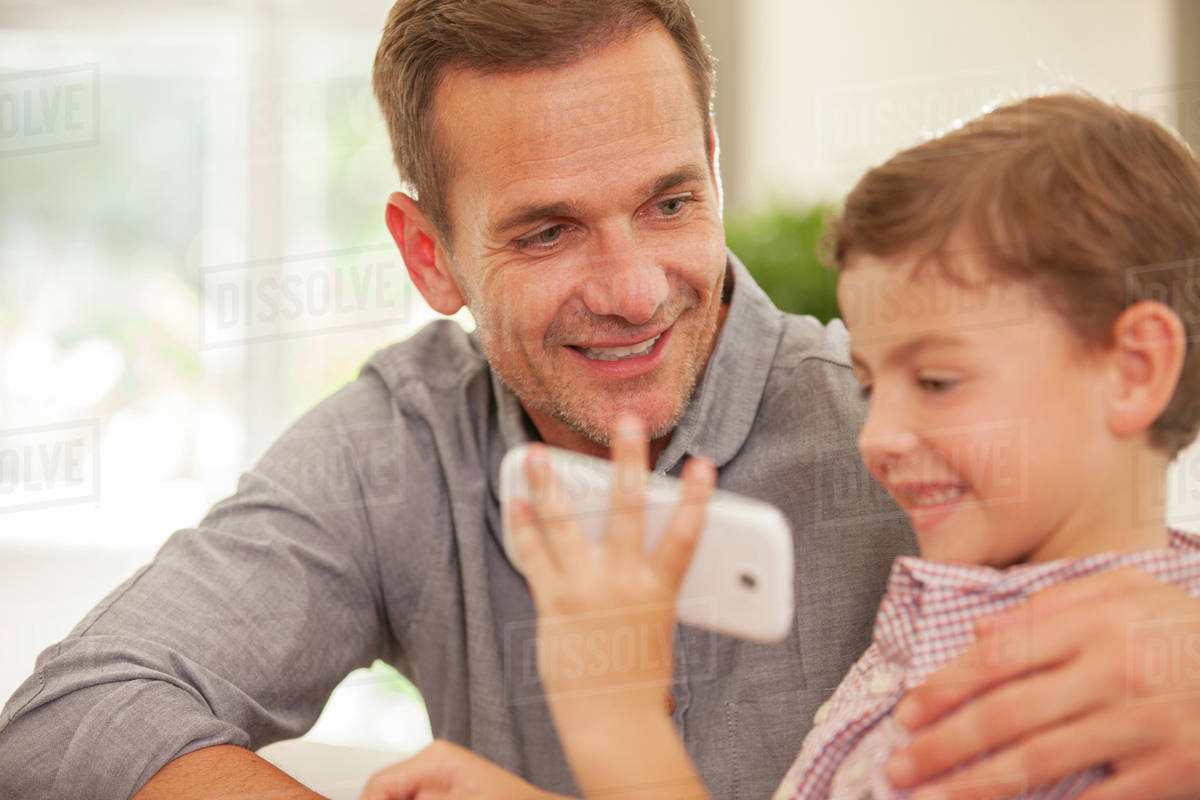 Father and son using cell phone - Royalty-free Stock Photo | Dissolve