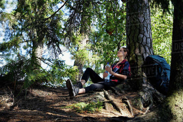 Young woman resting under tree - Royalty-free Stock Photo | Dissolve