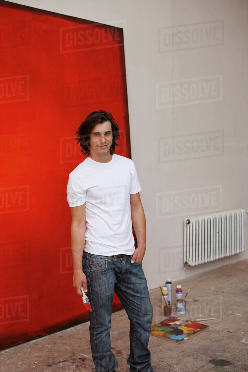 Artist working on big red painting - Stock Photo - Dissolve