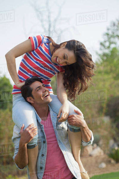 Man carrying woman on shoulders on sunny day - Royalty-free Stock Photo ...