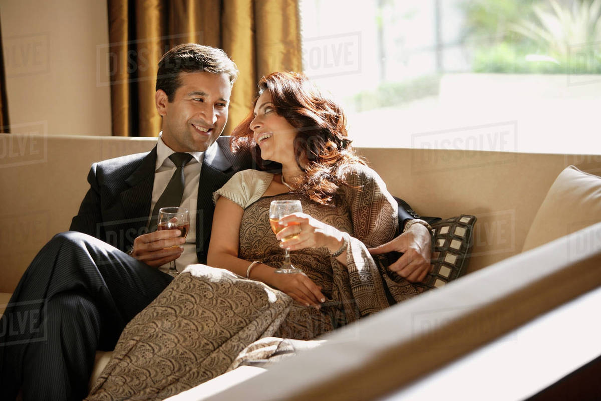 Couple on couch, smiling at each other - Royalty-free Stock Photo ...