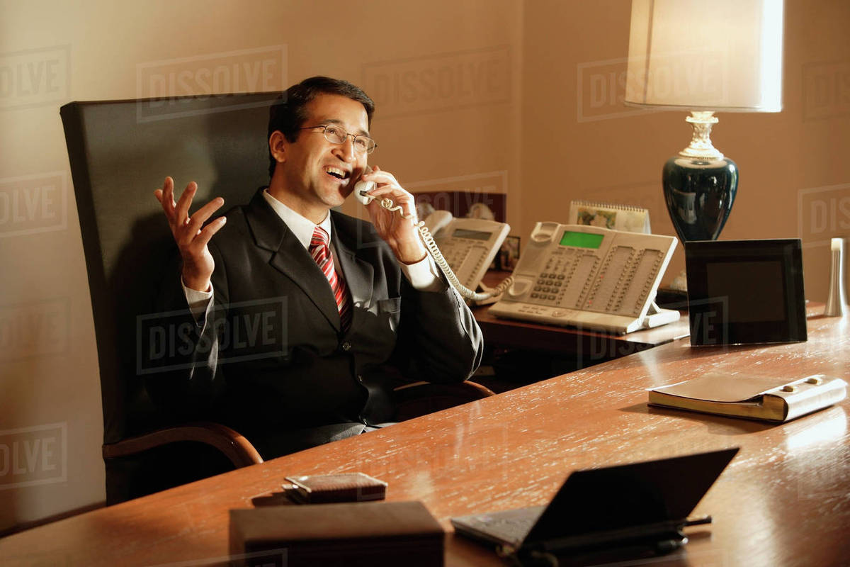 Businessman in office, on phone - Royalty-free Stock Photo | Dissolve