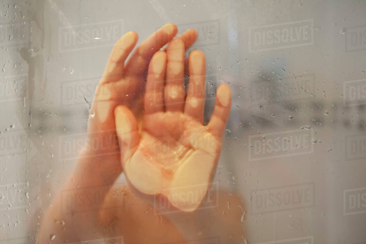 Palms pressing against the glass of a shower - Stock Photo - Dissolve