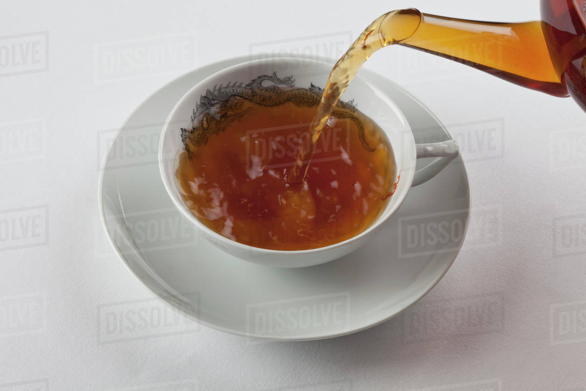 Detail of a cup of black tea being poured - Stock Photo - Dissolve
