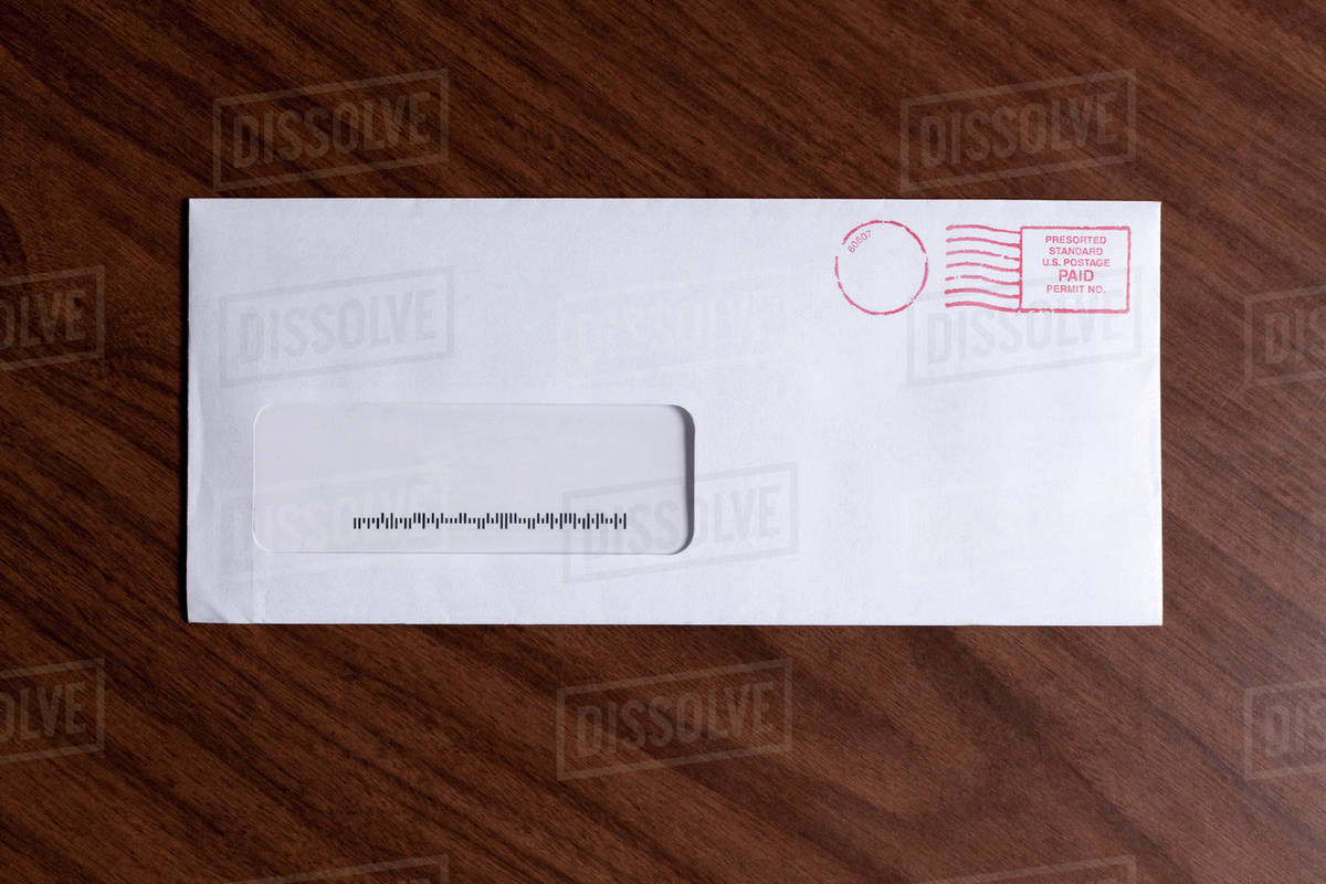 A window envelope with no address, but a barcode and red ink postage ...