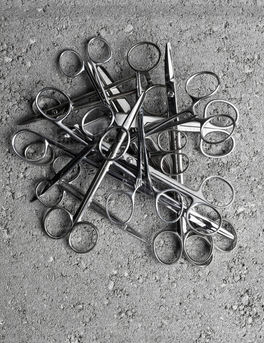 A pile of surgical scissors on cement - Royalty-free Stock Photo | Dissolve