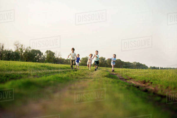 Children running in a field - Royalty-free Stock Photo | Dissolve