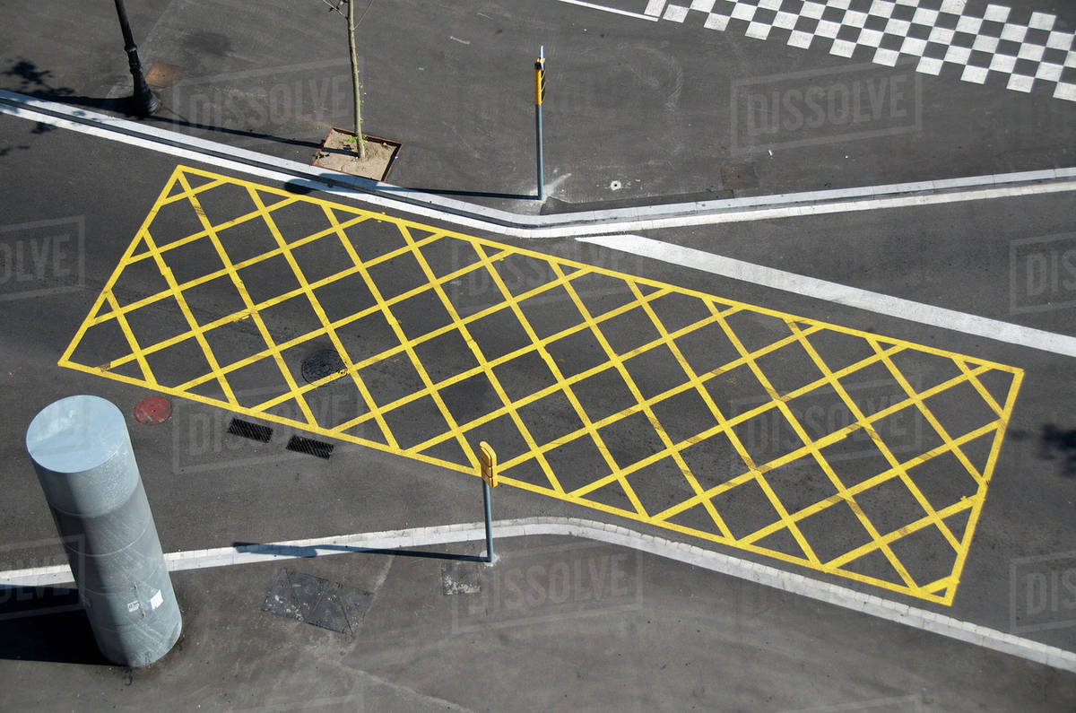 Yellow lines on the street to mark 'no-stopping area' near a red light ...