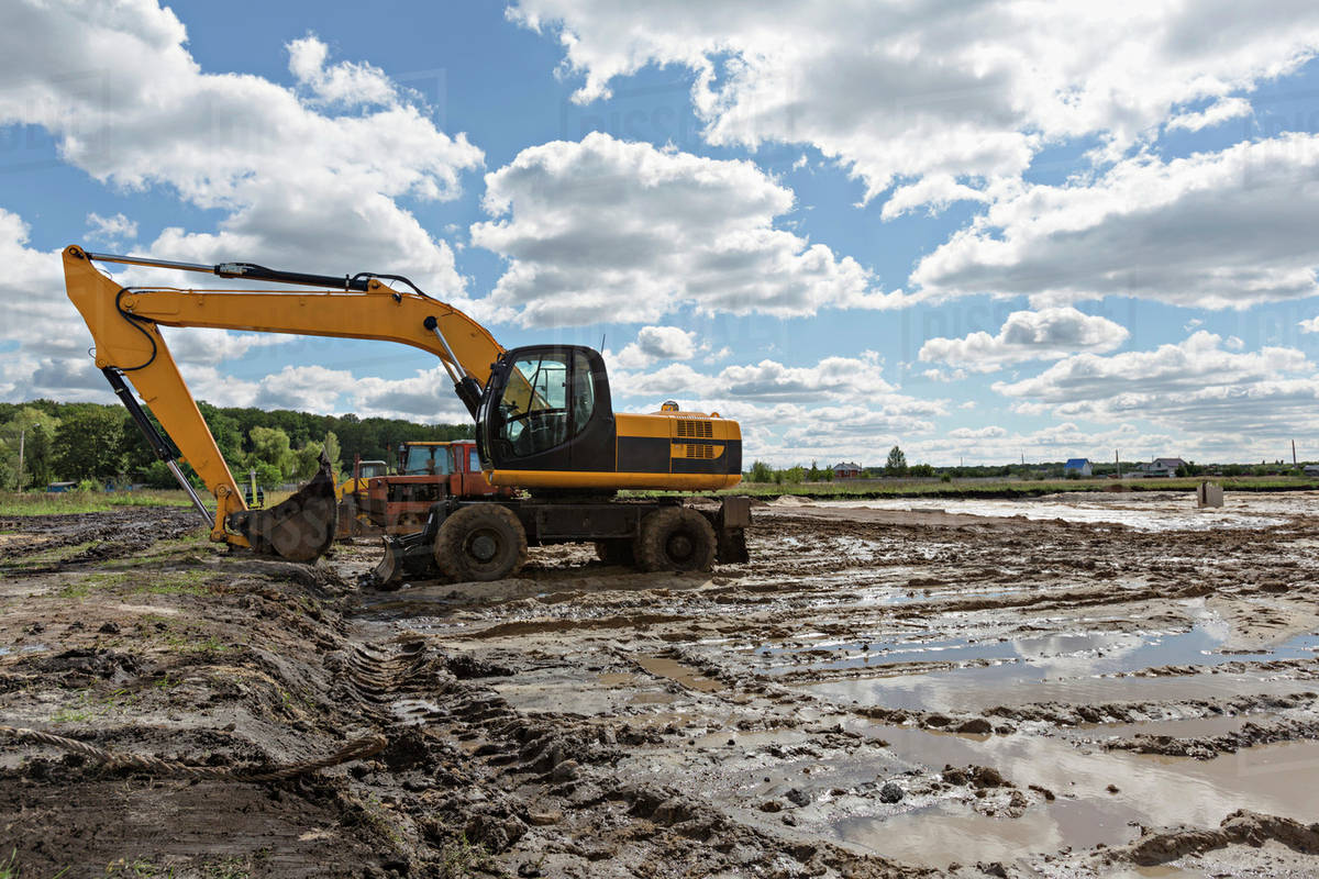 Digger on muddy construction site - Royalty-free Stock Photo | Dissolve