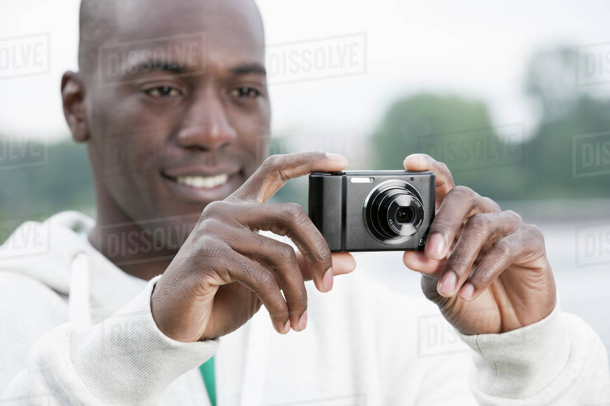 Man using digital camera - Stock Photo - Dissolve