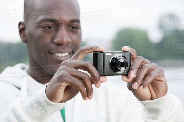 Man using digital camera - Stock Photo - Dissolve