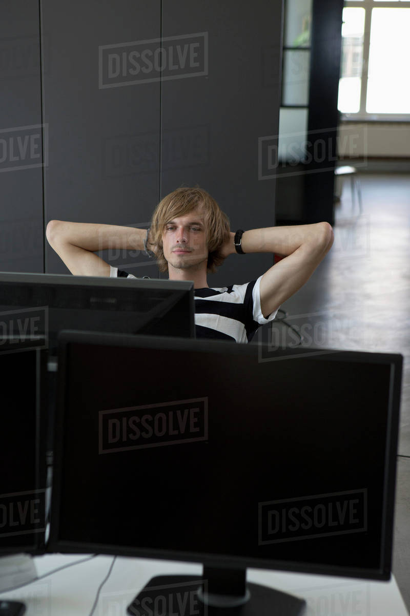 Man relaxing at computer desk - Royalty-free Stock Photo | Dissolve