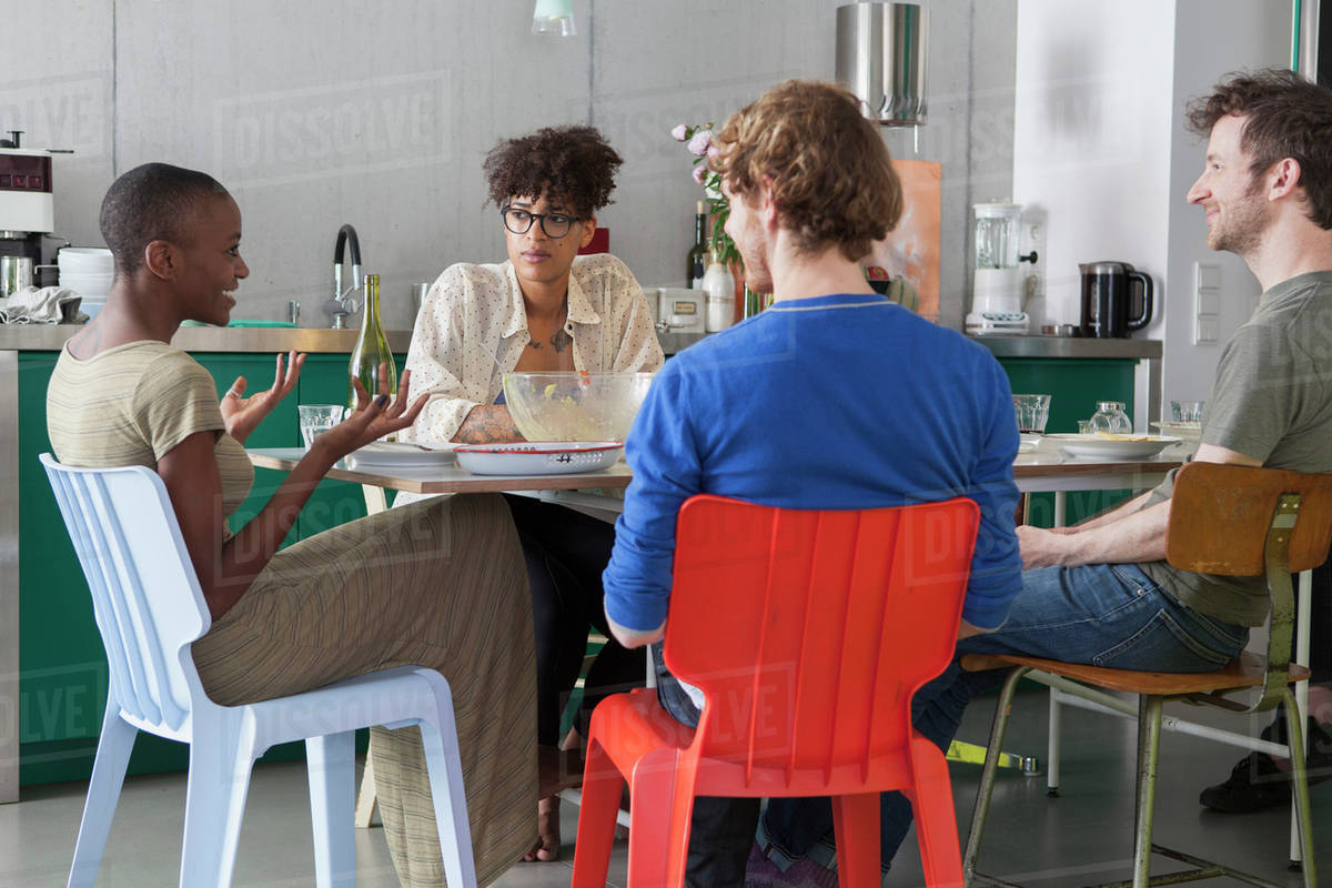 Happy woman talking with friends at dining table - Royalty-free Stock ...