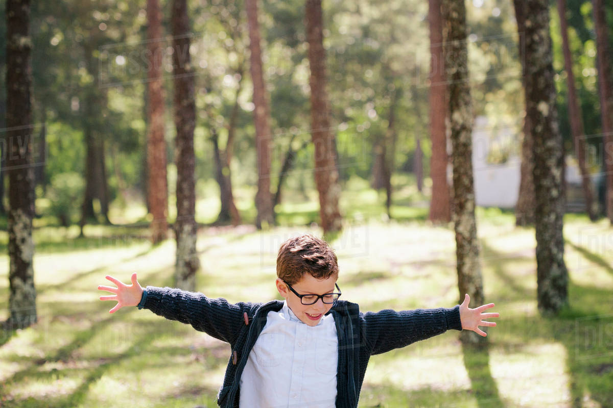 Happy boy with arms outstretched in forest - Royalty-free Stock Photo ...