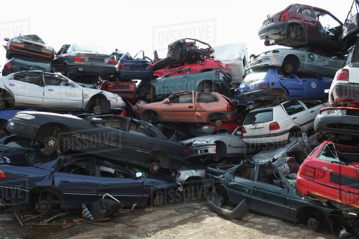 Cars stacked in scrap yard - Stock Photo - Dissolve