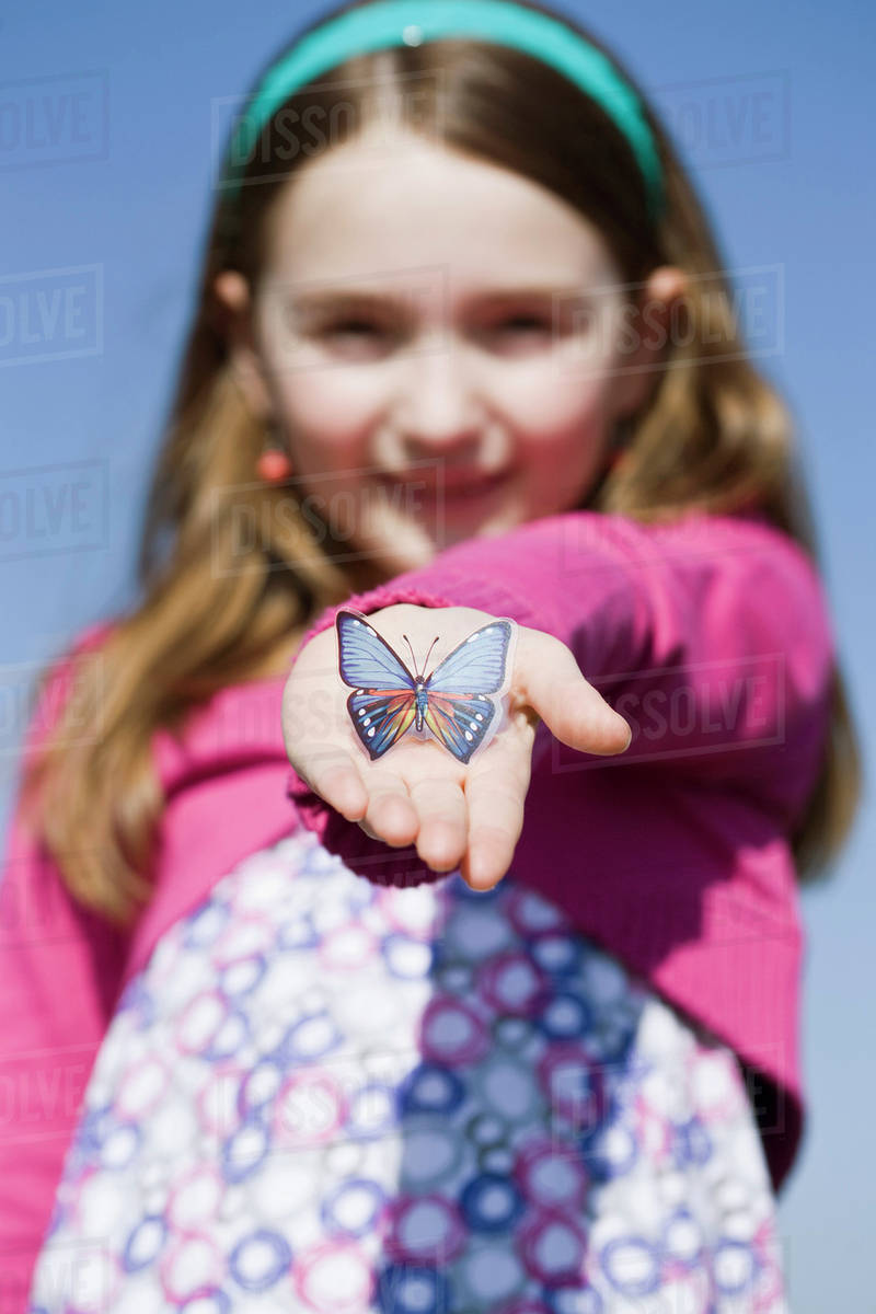 A girl holding a plastic butterfly in her hand - Royalty-free Stock ...