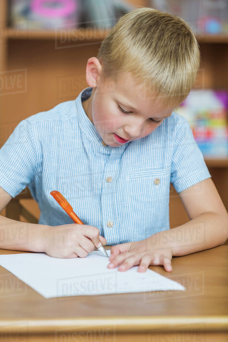Close-up of boy writing on paper at table - Royalty-free Stock Photo ...