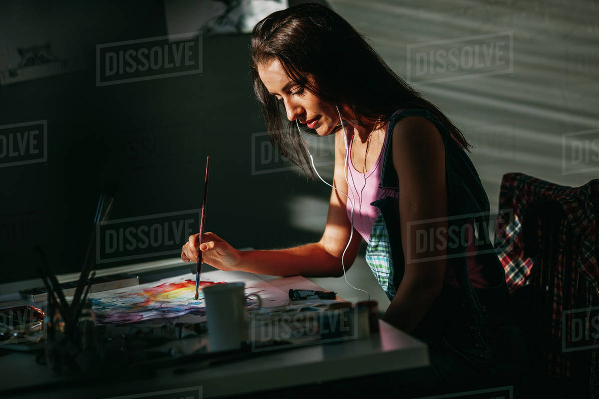Female artist painting at table in art studio - Royalty-free Stock ...