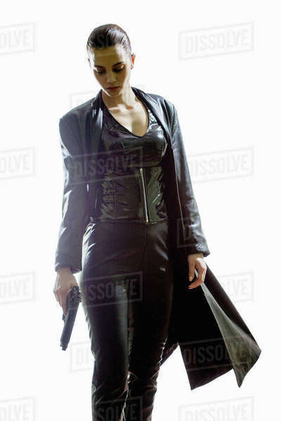 Female spy holding gun while walking against white background - Stock ...