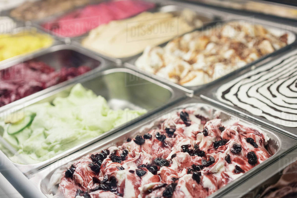 Various ice creams in containers on display at store - Stock Photo ...