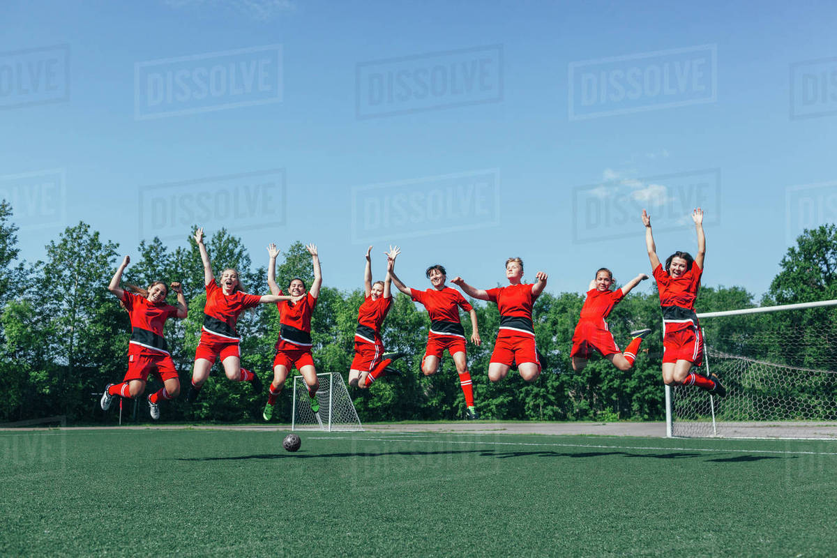 Happy soccer team cheering on field against sky - Royalty-free Stock ...