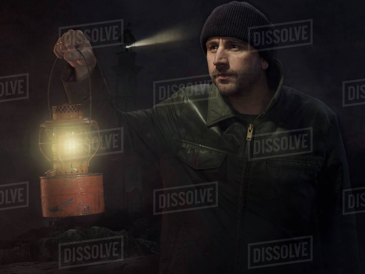 Thoughtful man holding illuminated lantern at night - Royalty-free ...