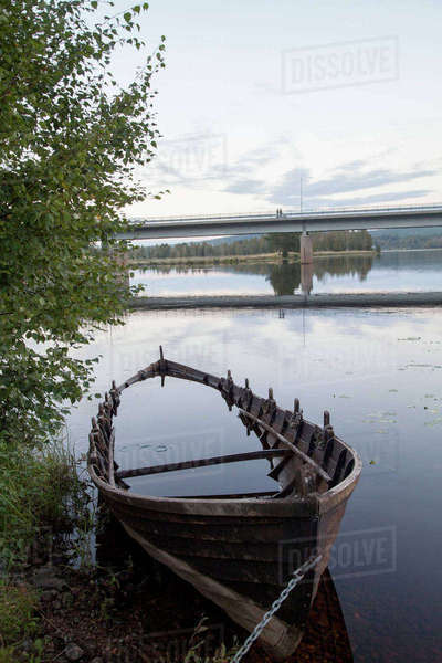 Rowboat sinking in lake against sky - Royalty-free Stock Photo | Dissolve