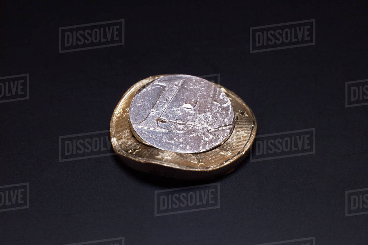 Close-up of dented one Euro coin against black background - Stock Photo ...