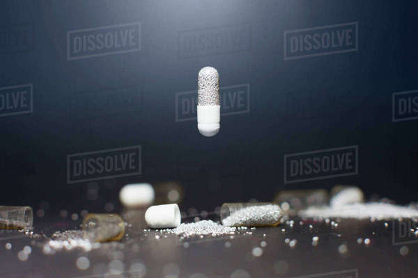 Silver capsule levitating in mid-air against gray background - Stock ...