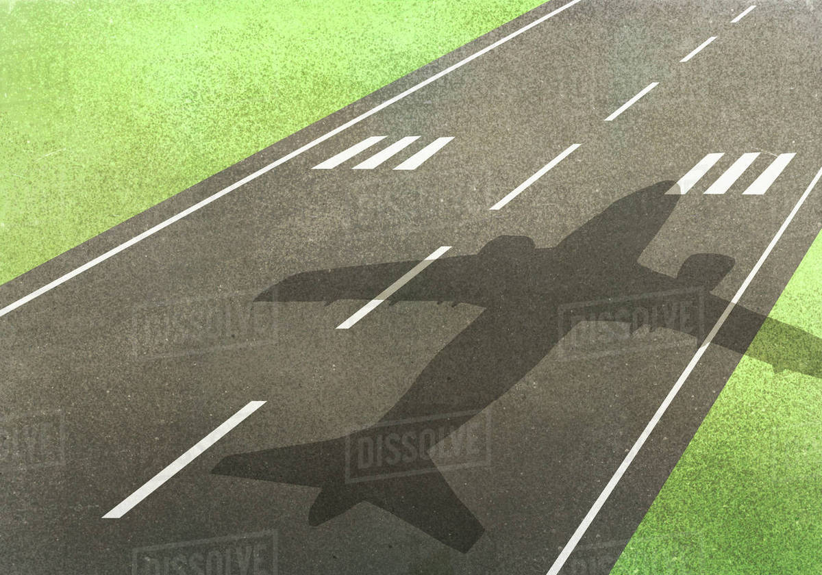 Shadow of airplane on runway amidst field - Stock Photo - Dissolve