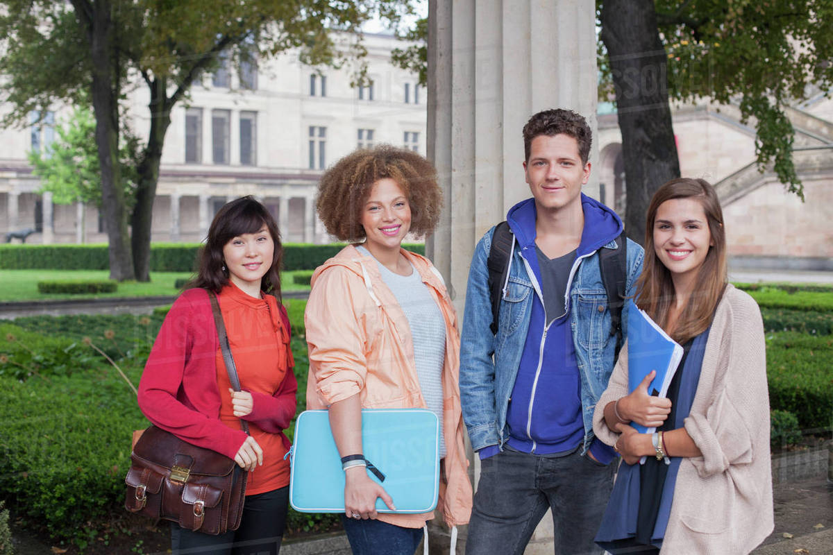 Portrait of young friends standing against column, Berlin, Germany ...