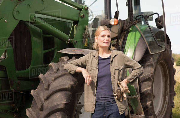 Portrait of mature woman standing by tractor on sunny day - Royalty ...