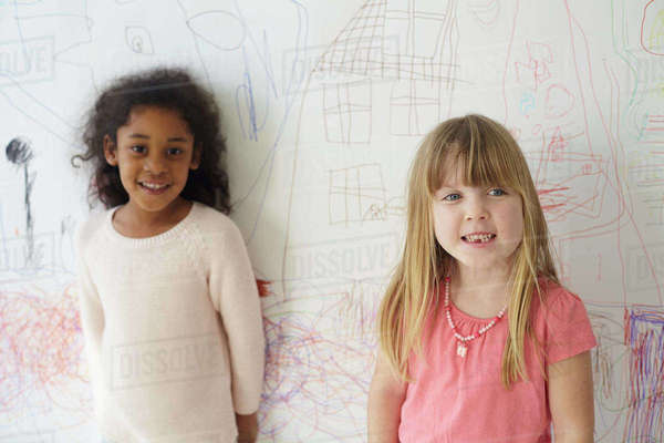 Portrait of girls standing against drawing on wall - Stock Photo - Dissolve