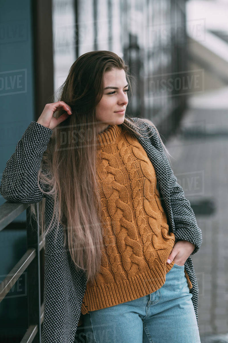 Young woman leaning against railing, looking away - Royalty-free Stock ...