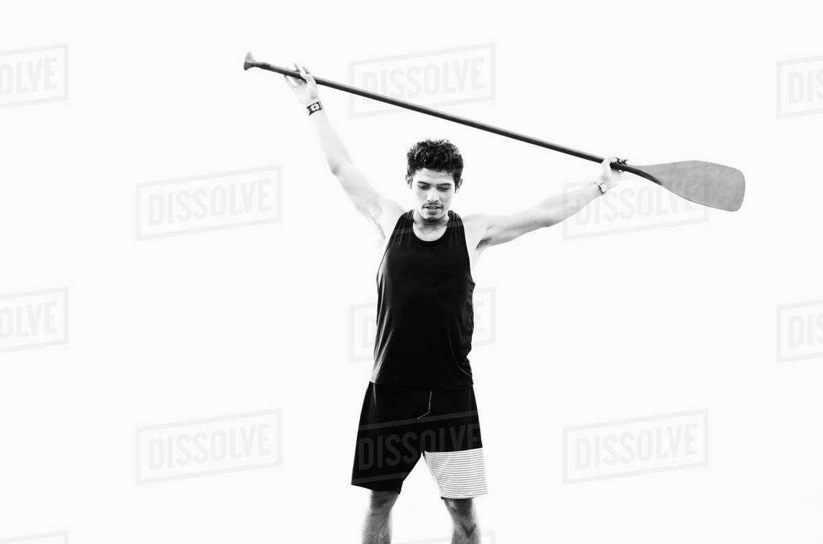 Young, fit man holding oar overhead - Royalty-free Stock Photo | Dissolve